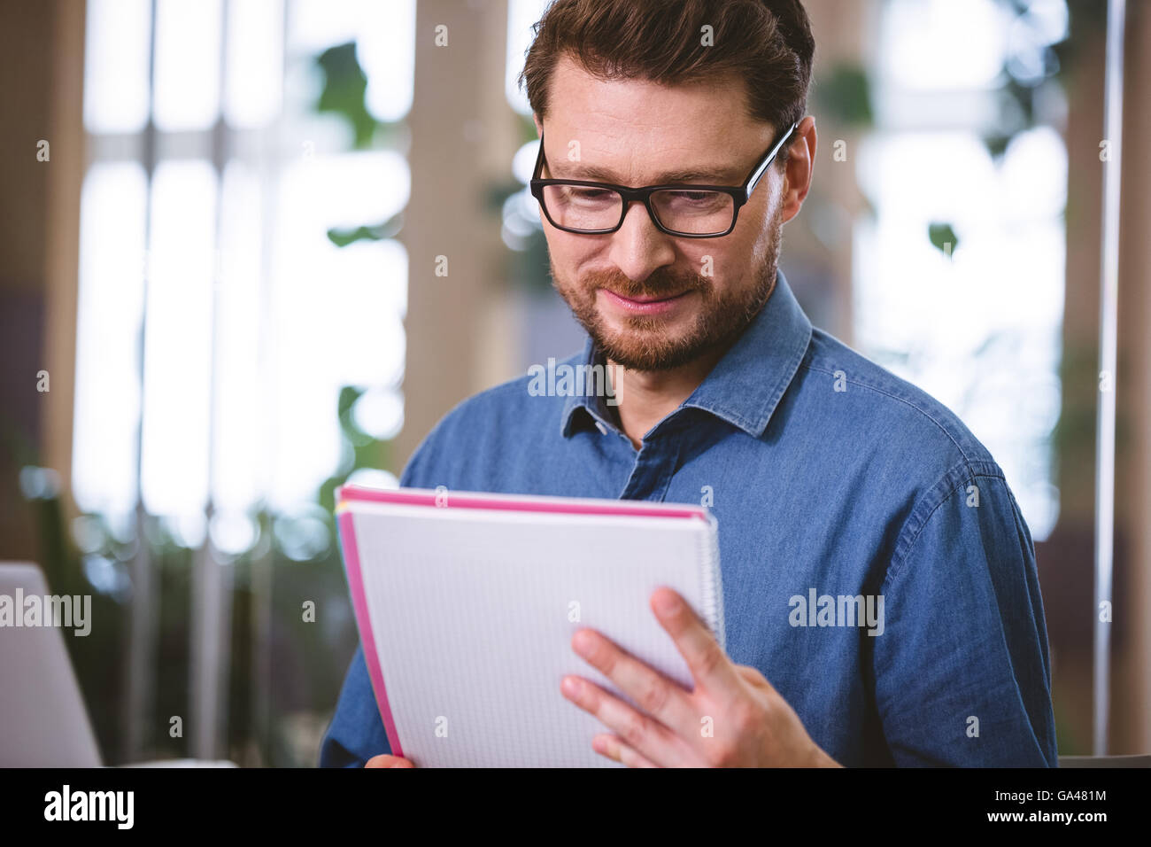 Confident executive reading documents at creative office Stock Photo ...
