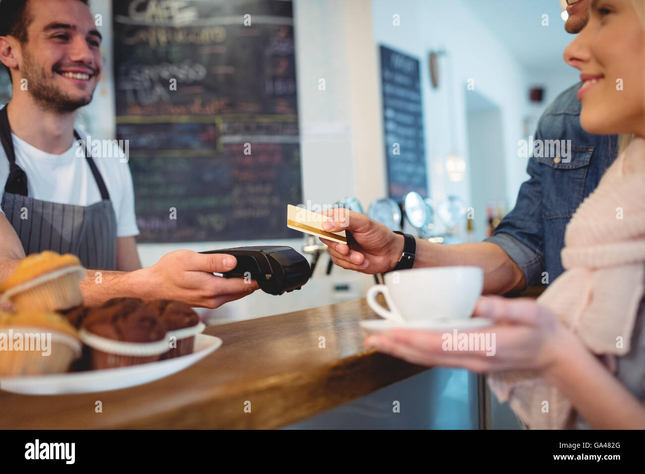Happy customers and barista at coffee shop Stock Photo - Alamy