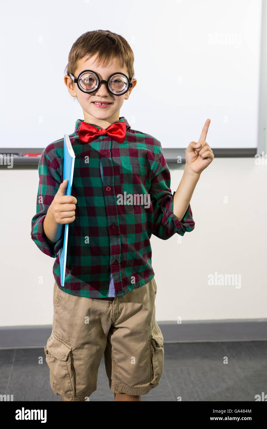 Portrait of cute boy raising hand in classroom Stock Photo - Alamy