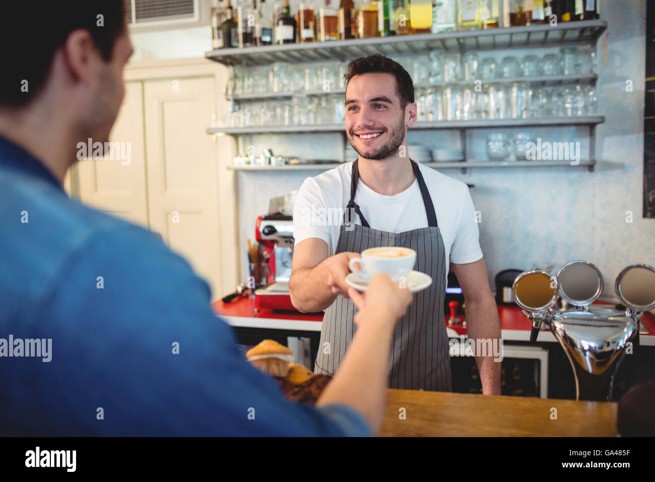 Happy waiter giving coffee to customer at cafe Stock Photo - Alamy