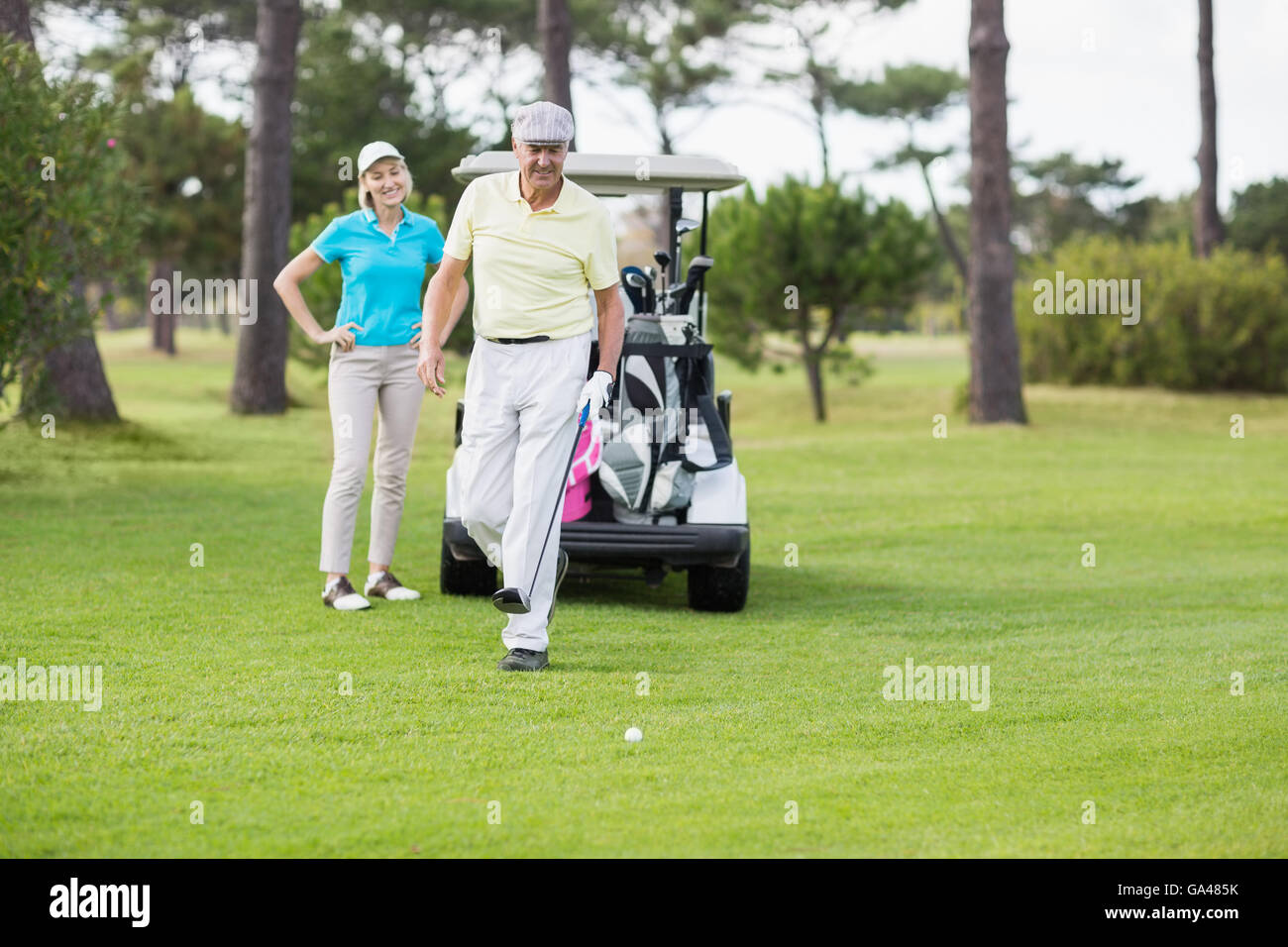 Couple standing at golf course Stock Photo - Alamy