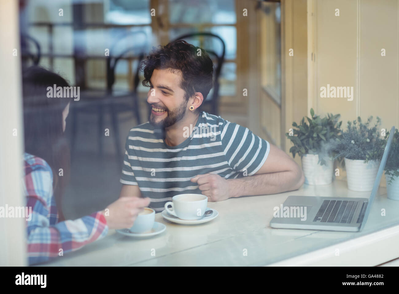 Happy couple talking at coffee shop Stock Photo - Alamy