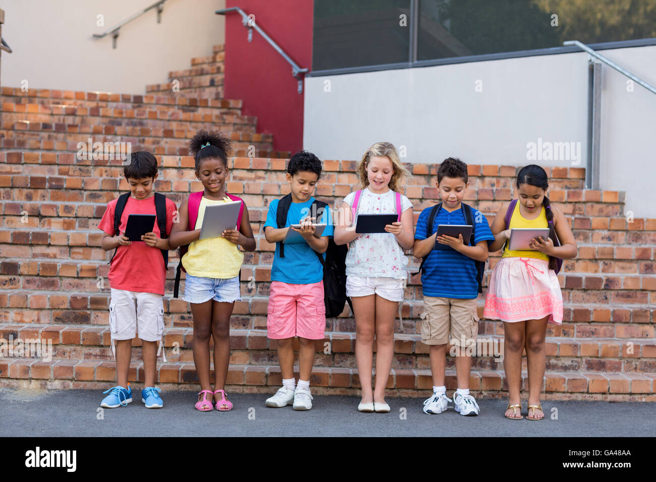 Full length of students using digital tablets Stock Photo - Alamy