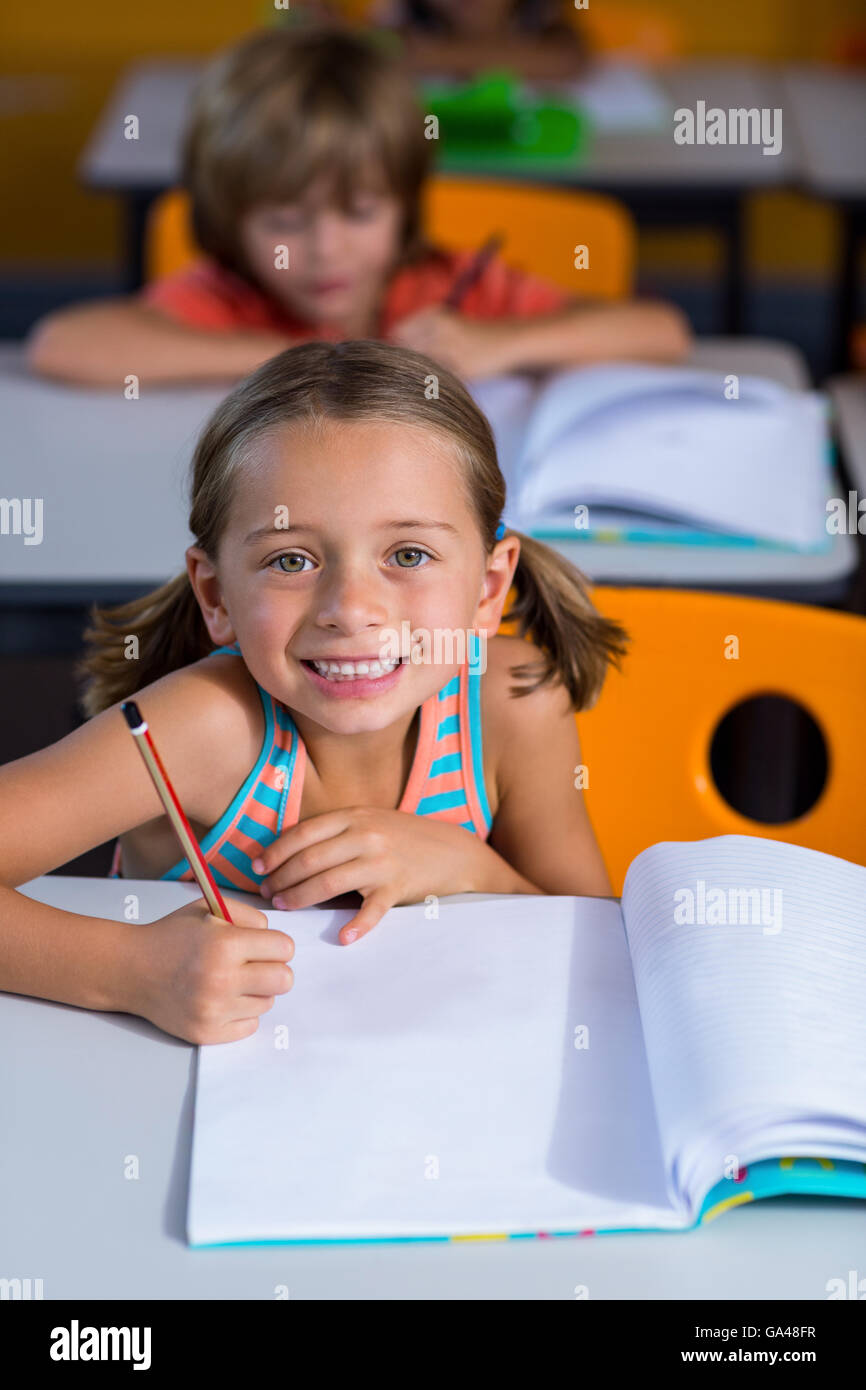 Cute girl writing on book Stock Photo - Alamy