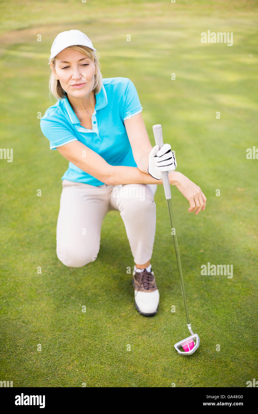 Golfer woman crouching on golf course Stock Photo - Alamy