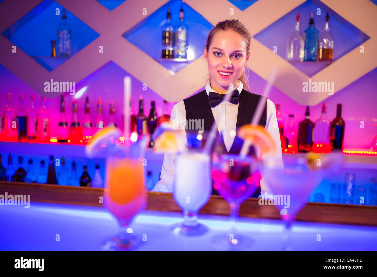 Pretty barmaid standing at bar counter Stock Photo - Alamy