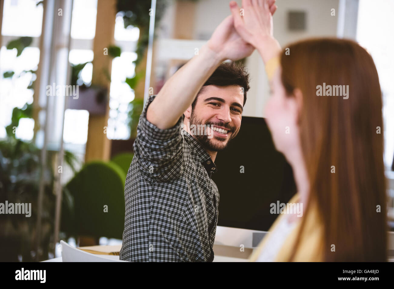 Businessman giving high-five to female coworker Stock Photo - Alamy