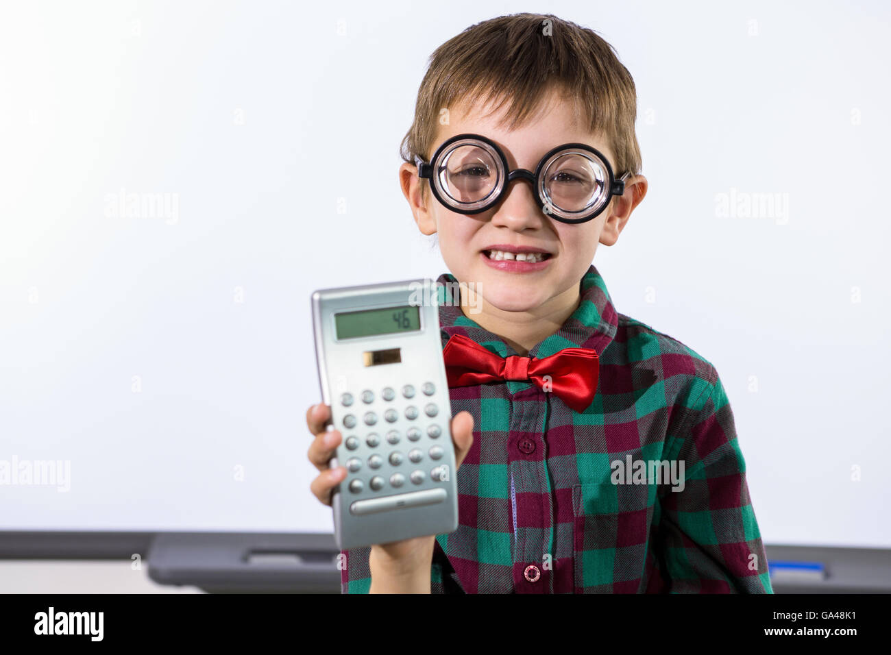 Smiling boy holding calculator in classroom Stock Photo - Alamy