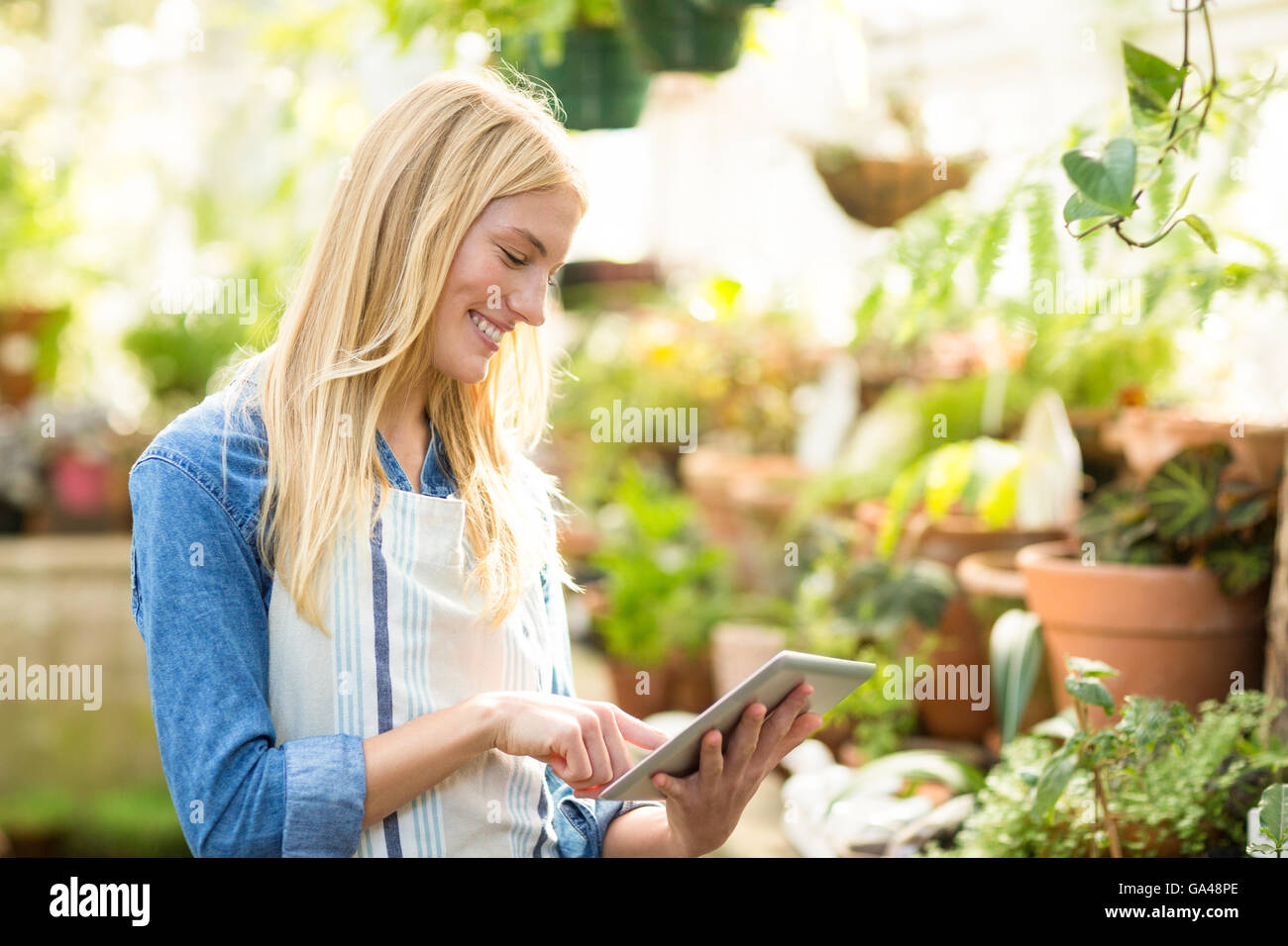 Female gardener using digital tablet at greenhouse Stock Photo - Alamy Female gardener using digital tablet at greenhouse Stock Photo - Alamy