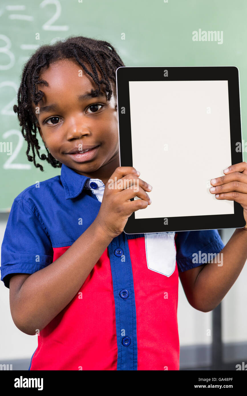 Smiling boy holding digital tablet in classroom Stock Photo - Alamy
