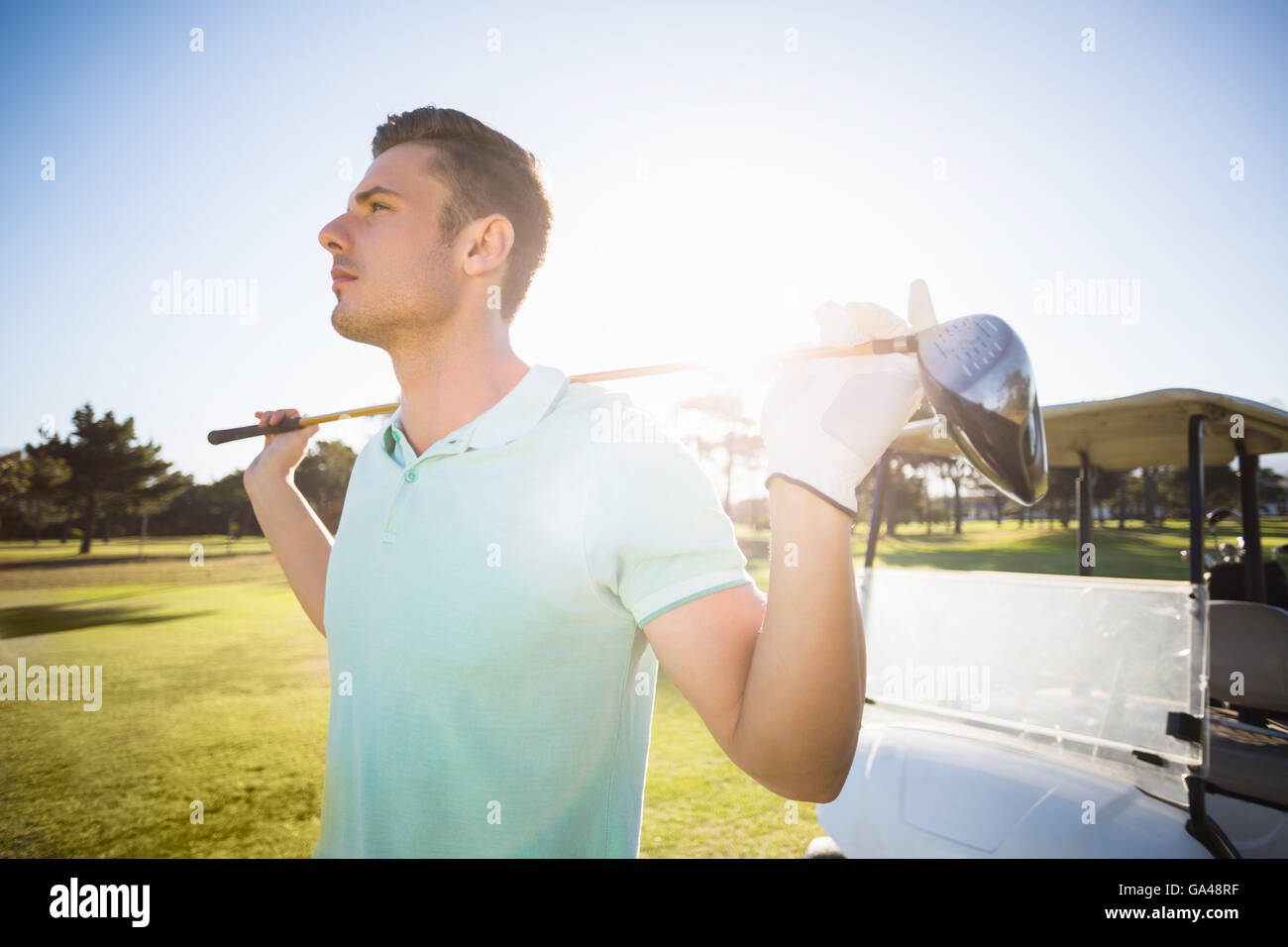 Smart man carrying golf club Stock Photo - Alamy