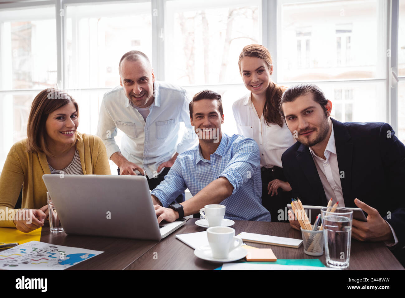 Smiling business people with laptop in meeting room Stock Photo - Alamy