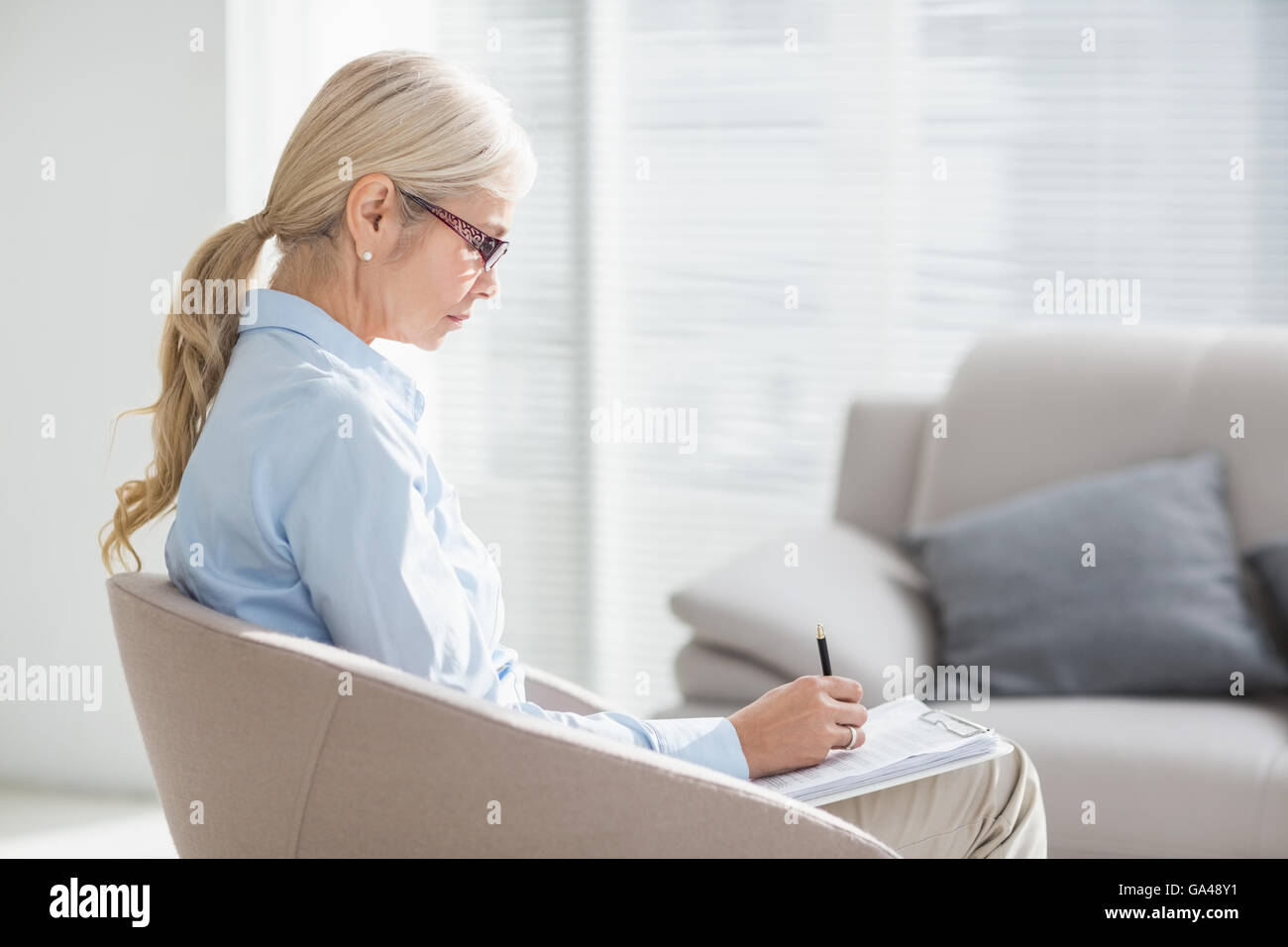 Therapist writing notes Stock Photo - Alamy