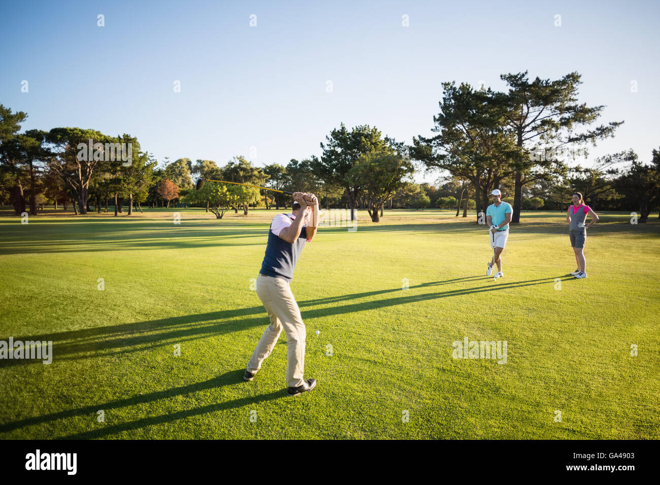 Full length of people playing golf Stock Photo - Alamy