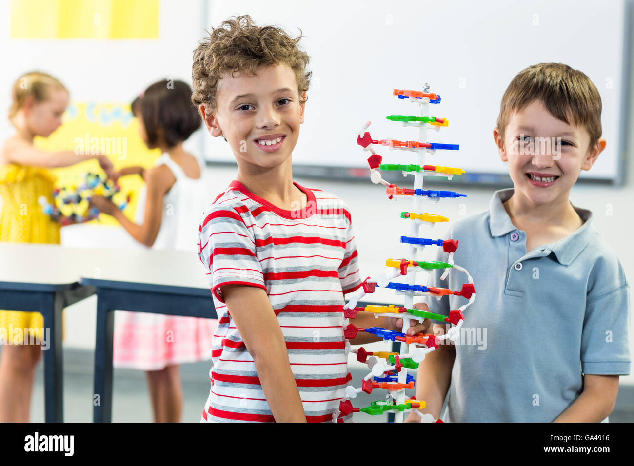 Cheerful boys holding DNA model Stock Photo - Alamy