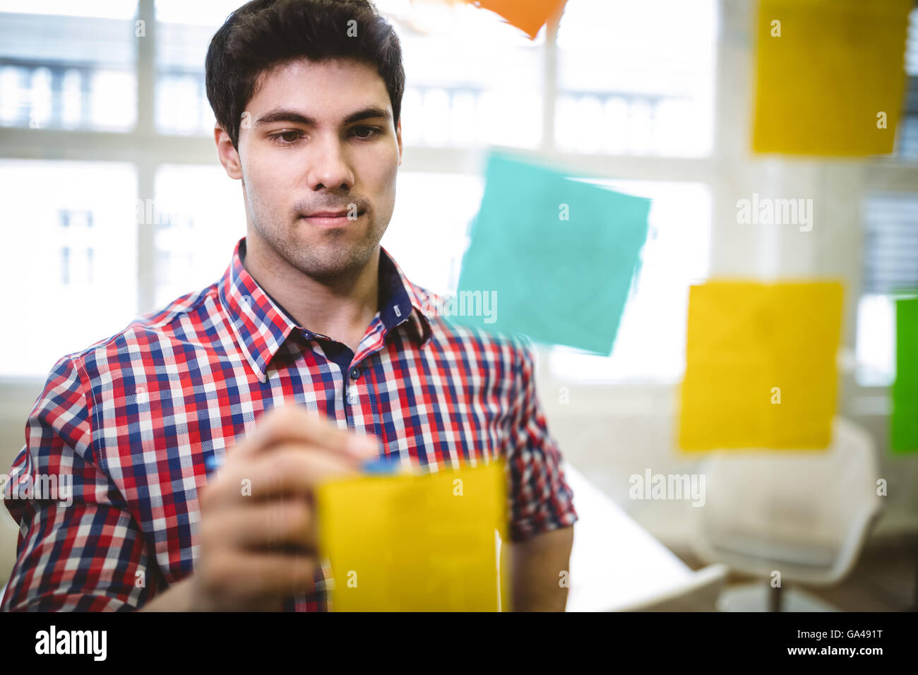 Businessman writing on sticky notes Stock Photo - Alamy