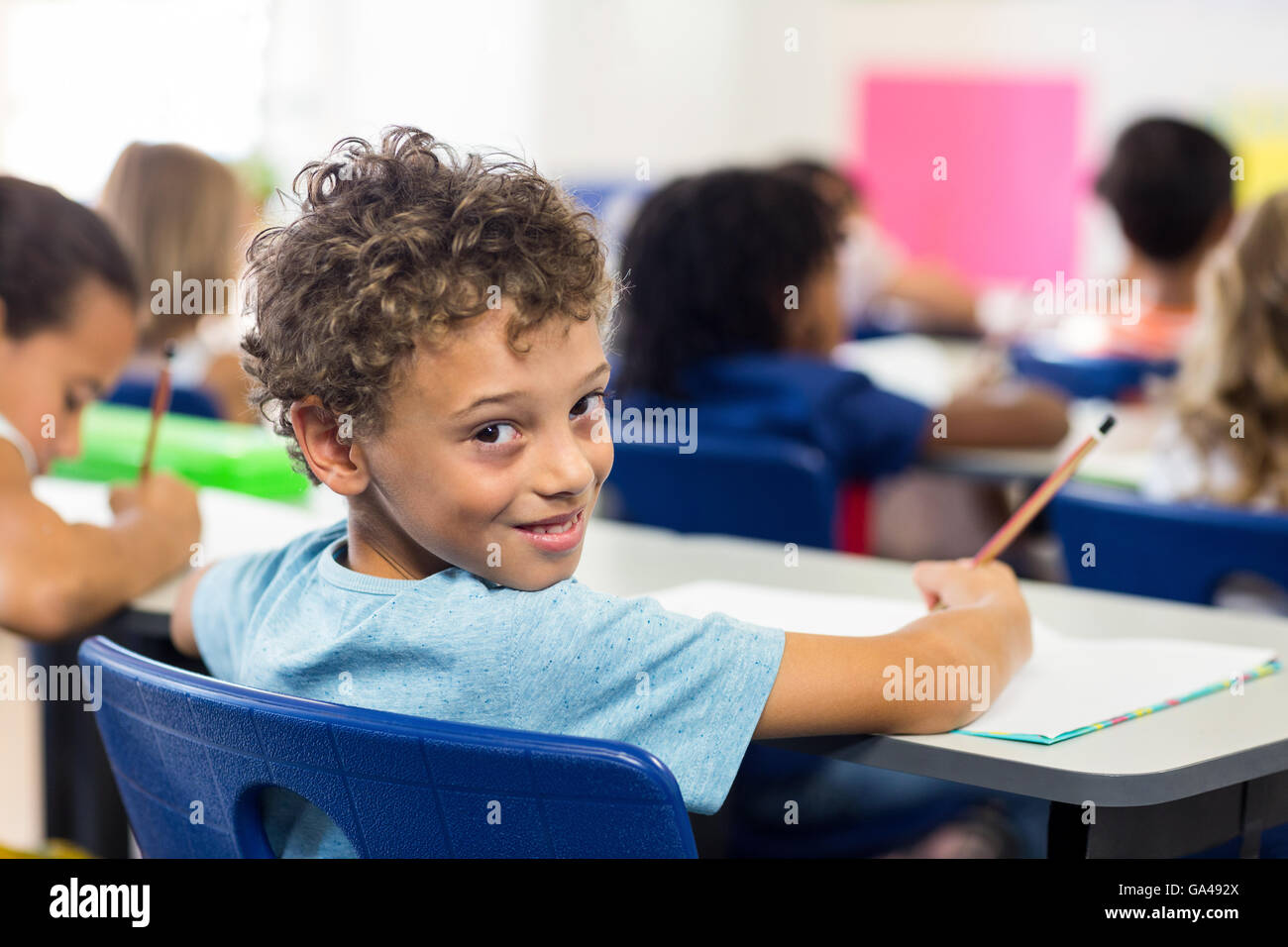 Smiling boy with classmates in classroom Stock Photo - Alamy
