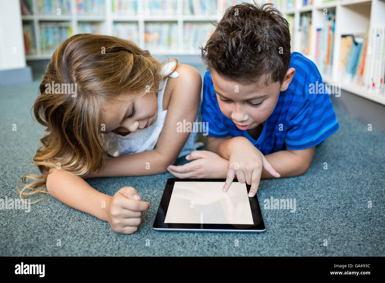 Girl and boy using digital tablet at library in school Stock Photo - Alamy