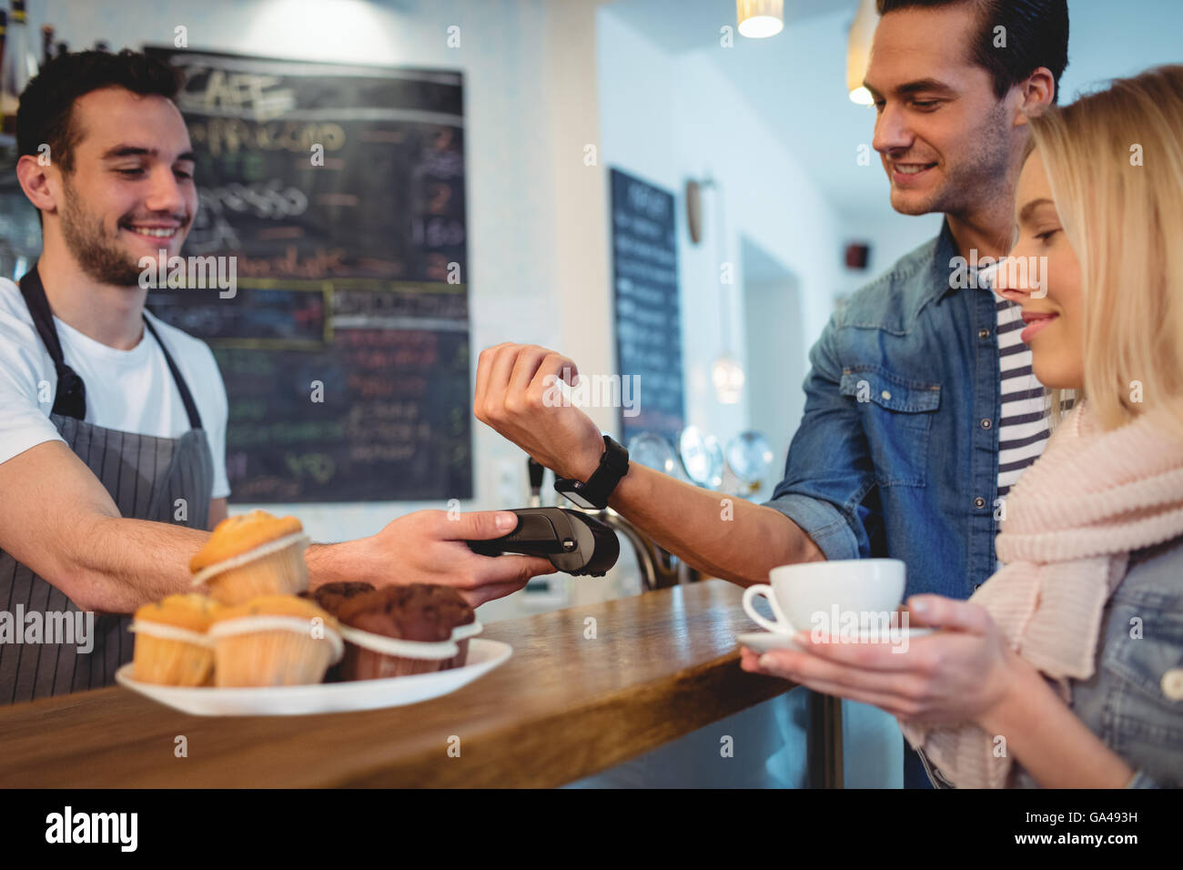 Happy customers with waiter at coffee shop Stock Photo - Alamy