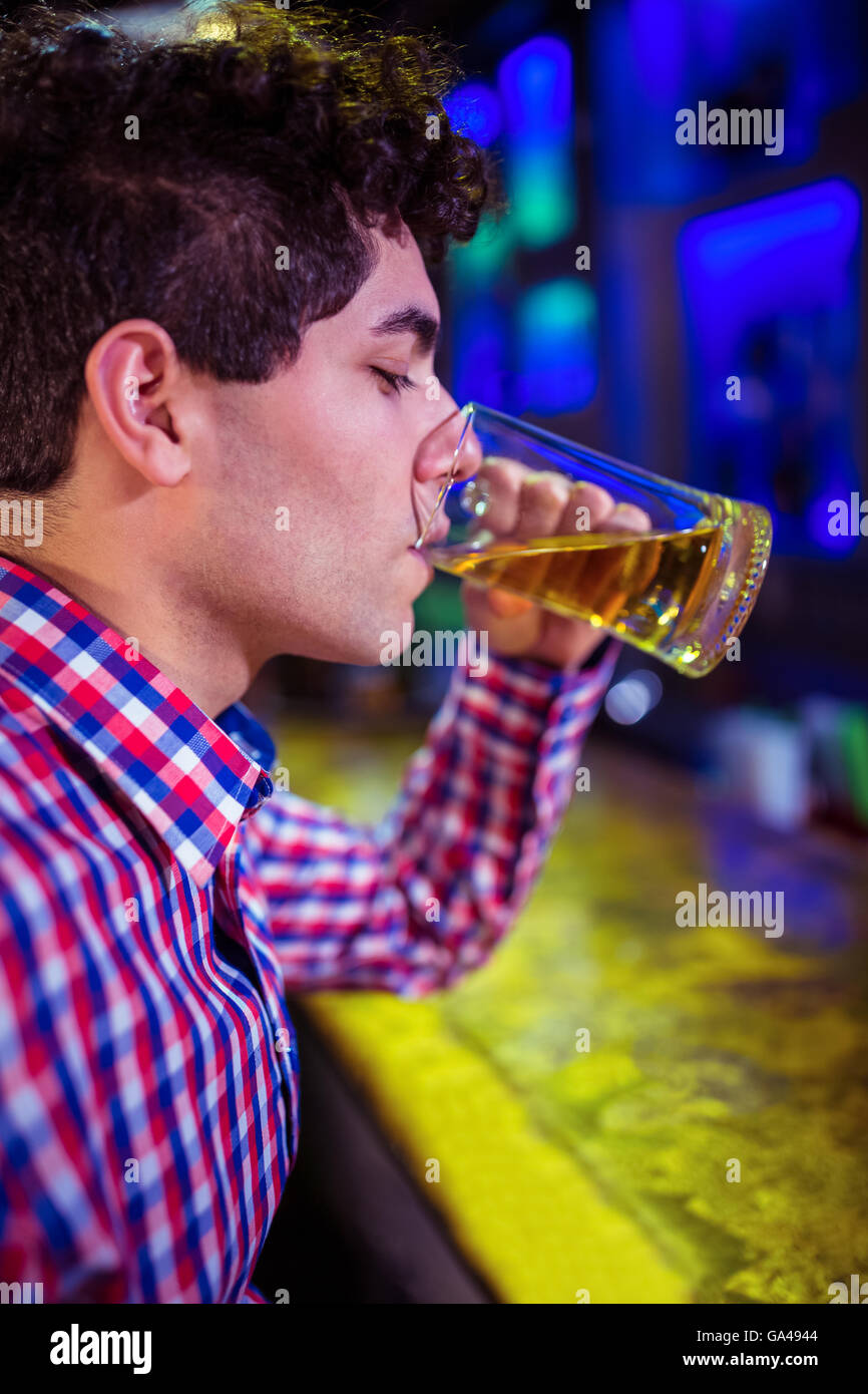 Man drinking beer at bar counter Stock Photo - Alamy