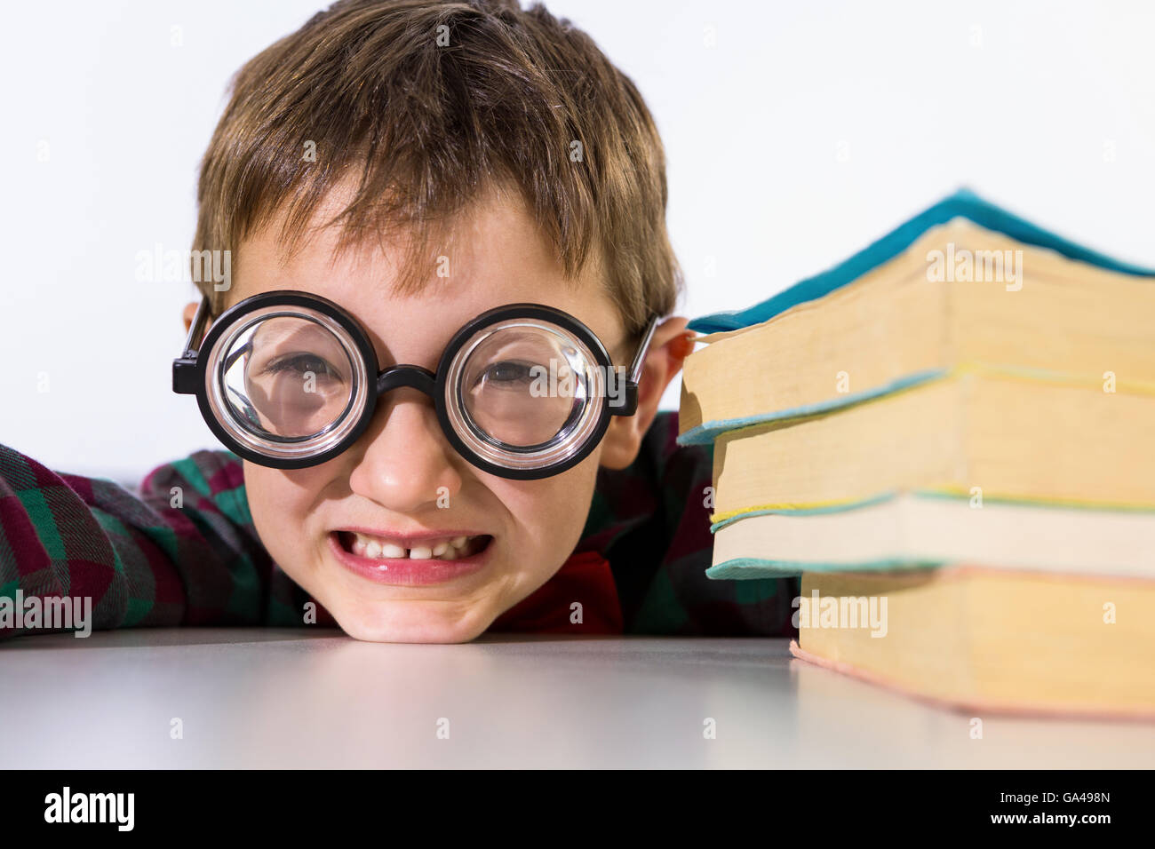Playful boy leaning on table in classroom Stock Photo - Alamy