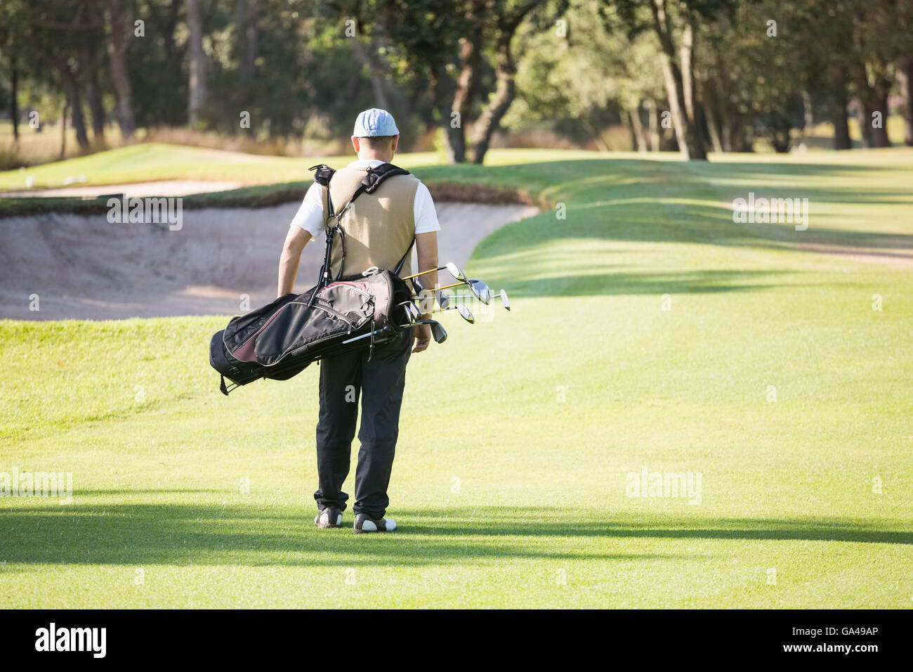 Rear view of sportsman walking with his golf bag Stock Photo - Alamy