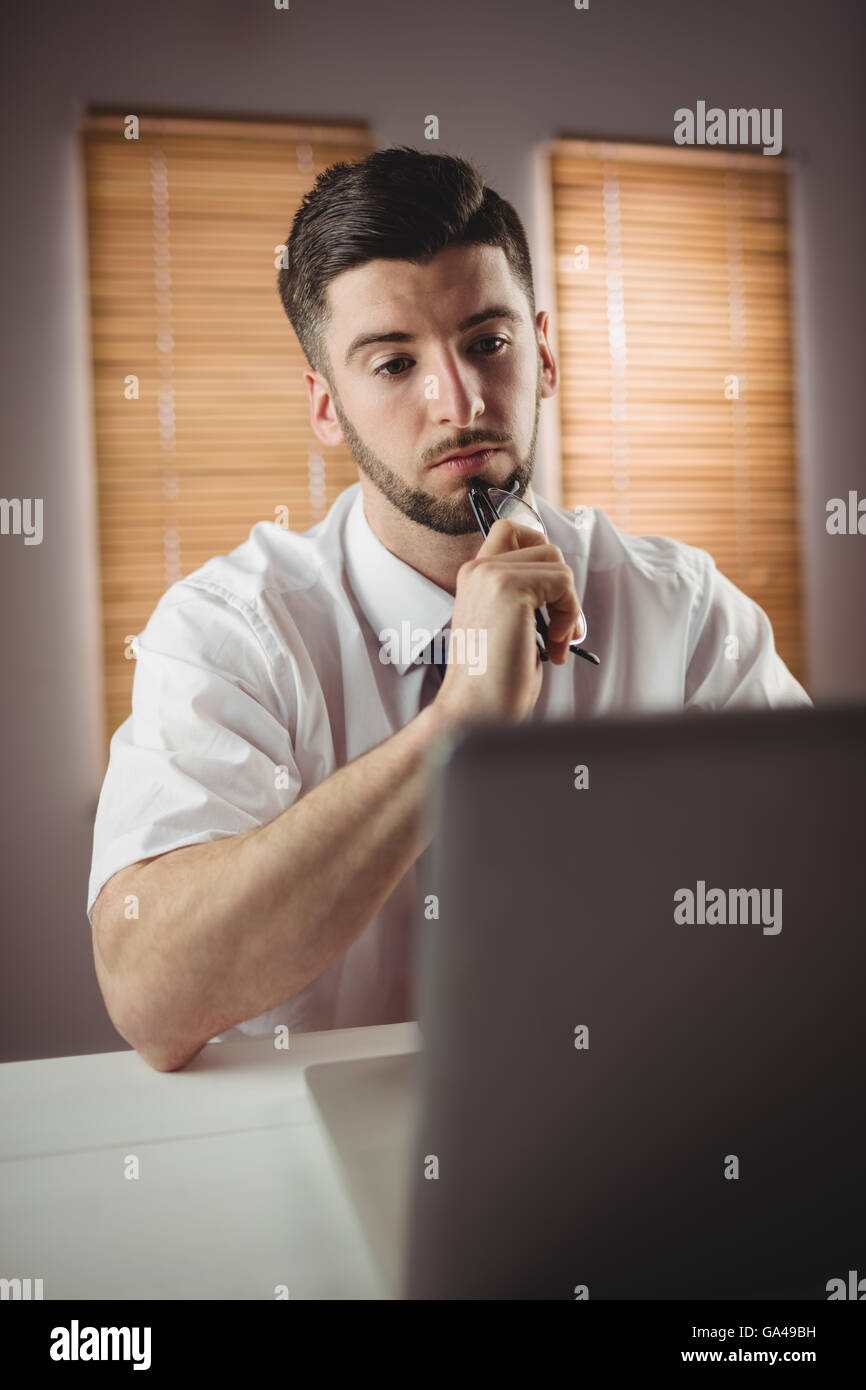 Thoughtful man working in office Stock Photo - Alamy