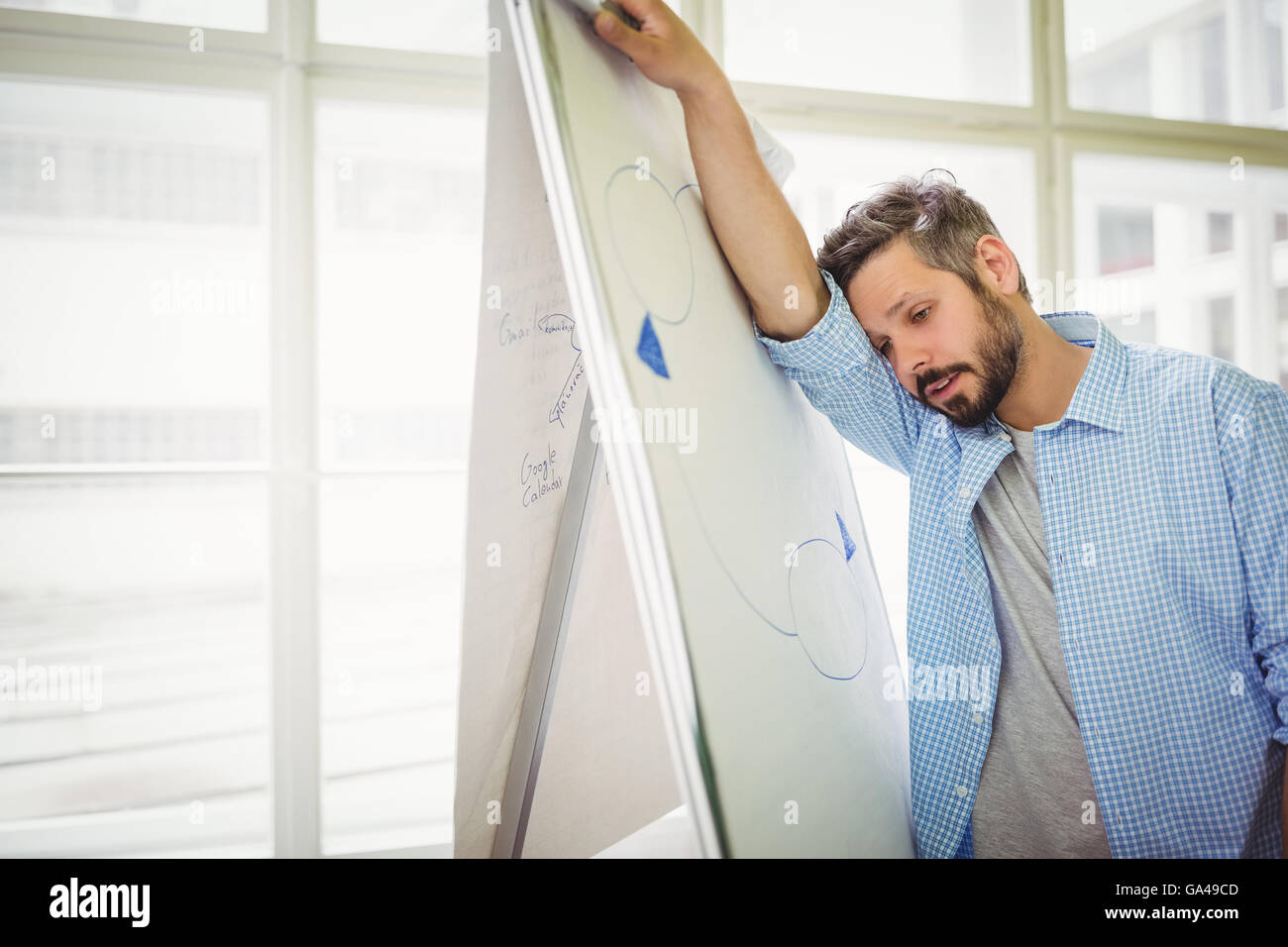 Tired businessman leaning on whiteboard in office Stock Photo - Alamy