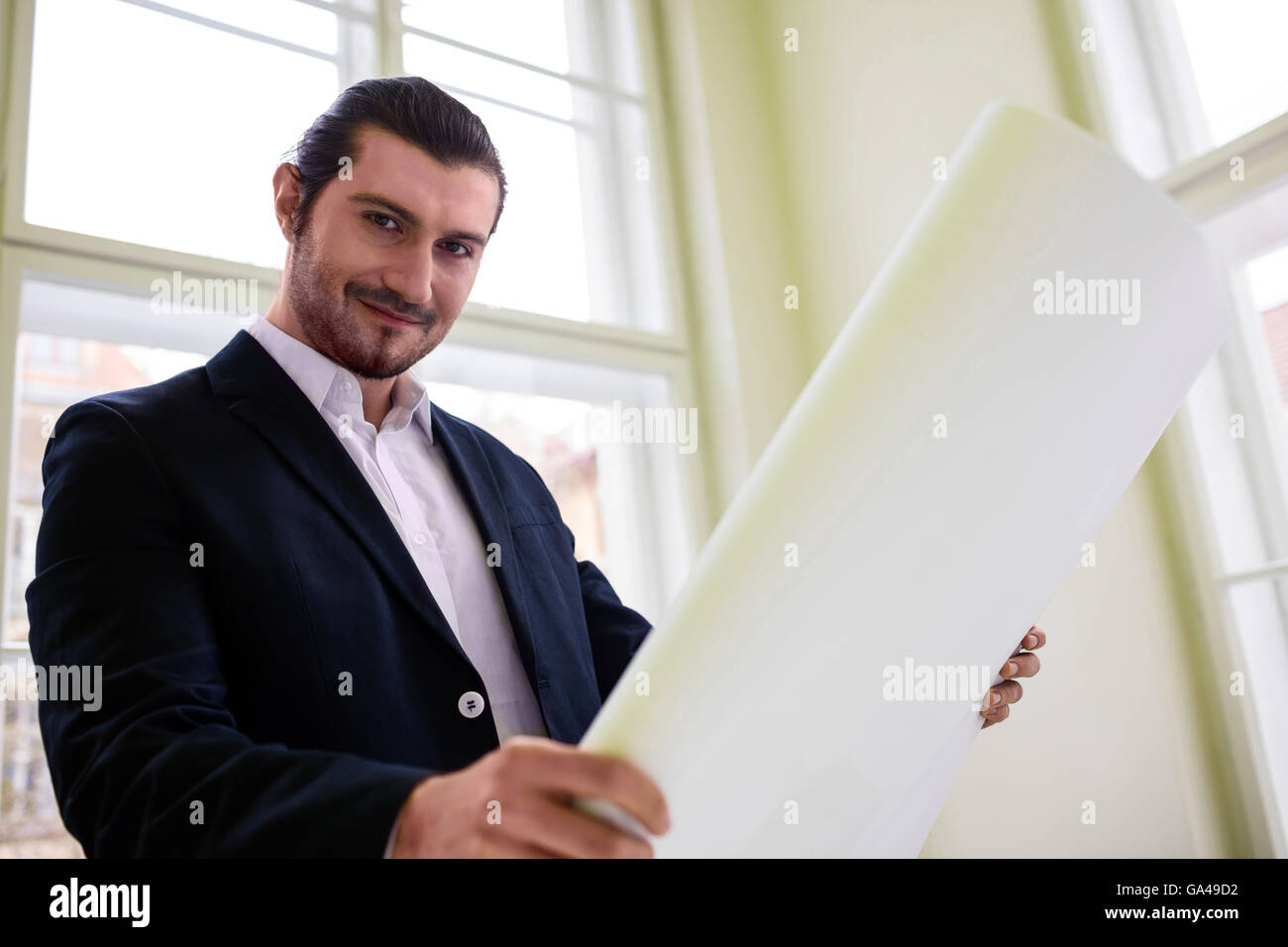 Portrait of architect holding blueprint Stock Photo - Alamy