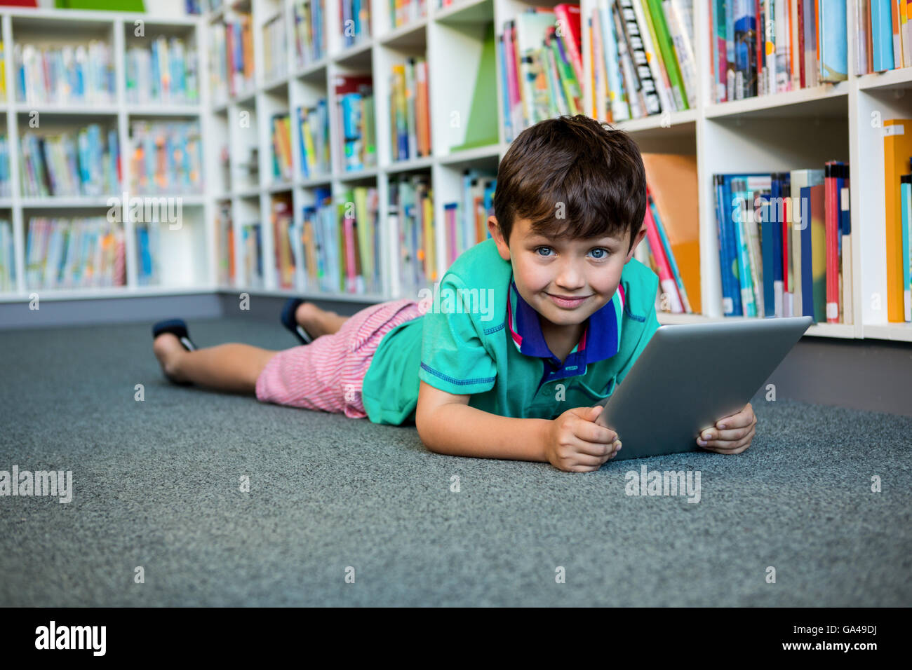 Portrait of boy using digital tablet in school library Stock Photo - Alamy