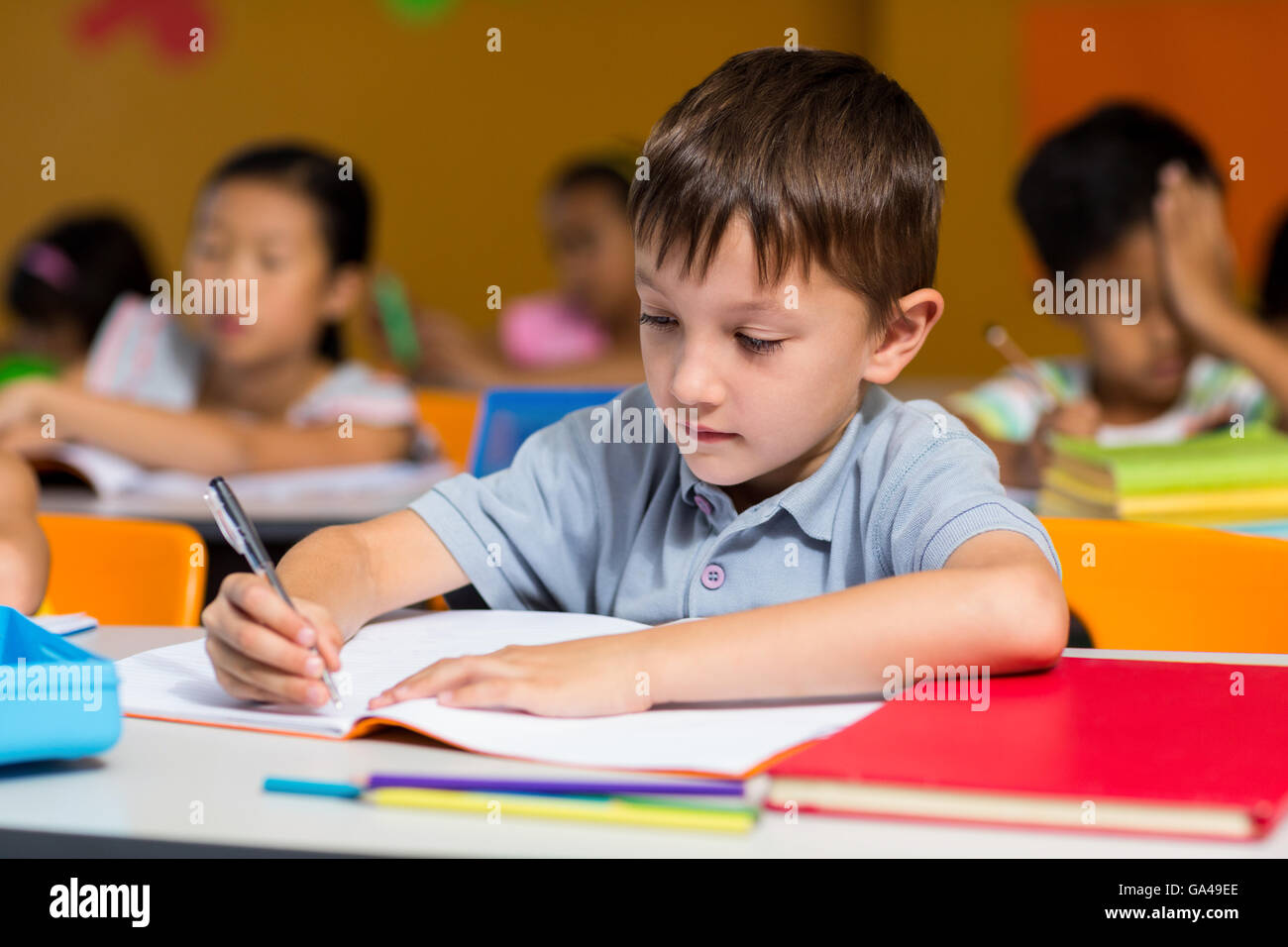 Innocent boy writing on book Stock Photo - Alamy