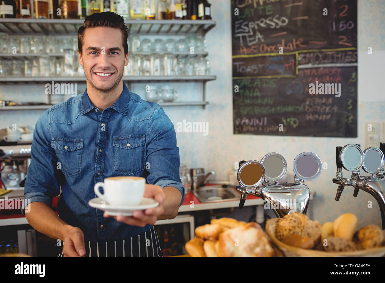 Portrait of happy owner offering coffee at cafeteria Stock Photo - Alamy