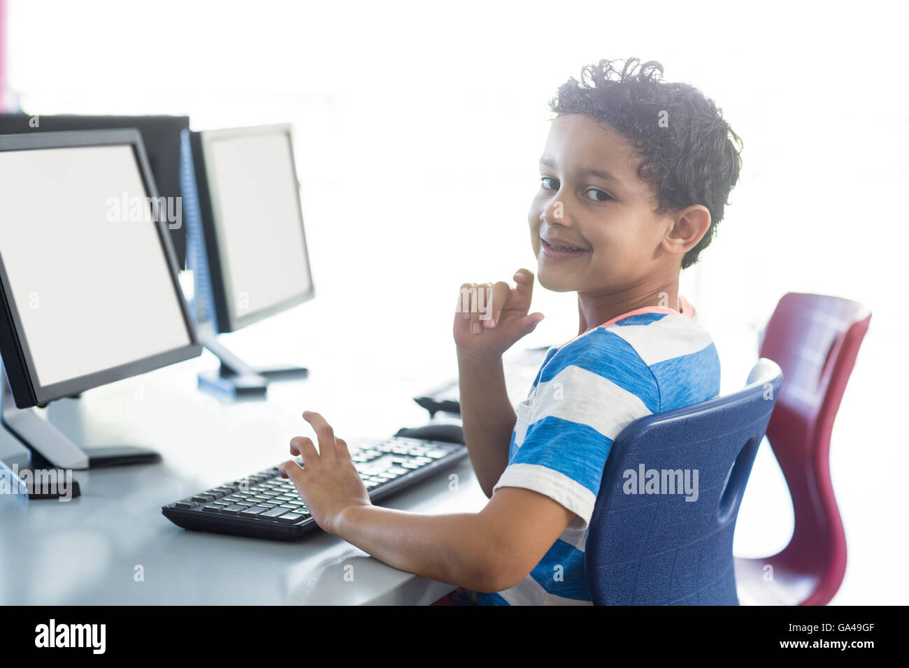Smiling boy using computer Stock Photo - Alamy