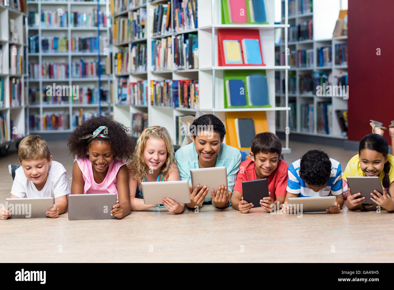 Teacher with students using digital tablet Stock Photo - Alamy