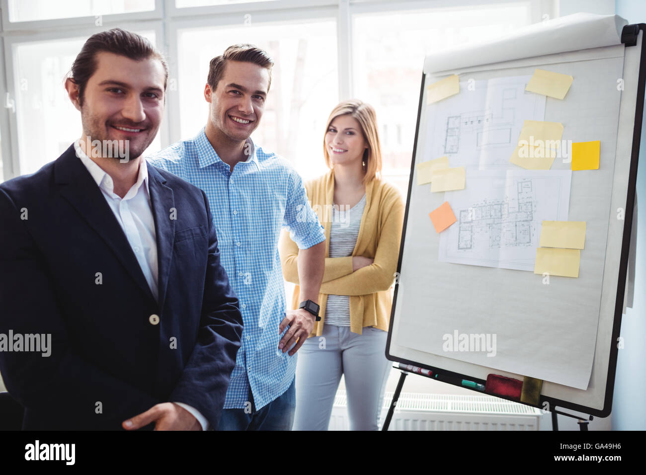 Smiling interior designers standing near board Stock Photo - Alamy