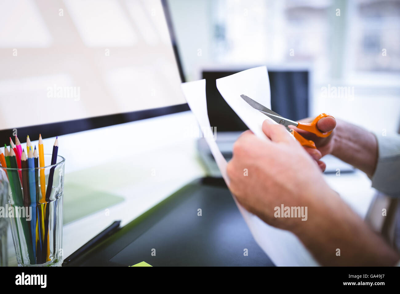 Cropped image of graphic designer cutting paper Stock Photo - Alamy