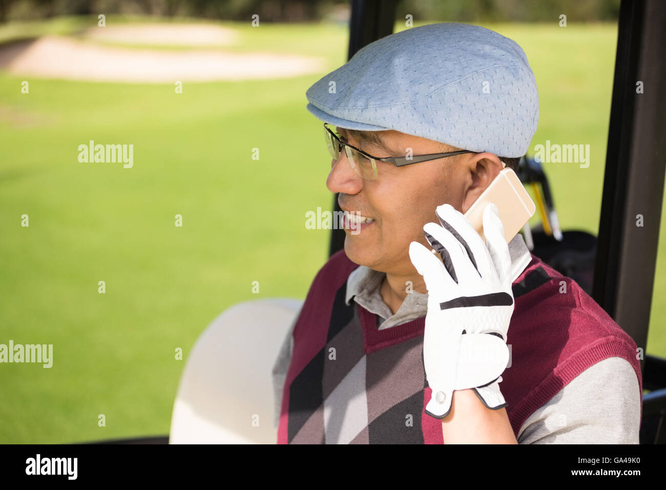 Profile view of golfer smiling and calling Stock Photo - Alamy