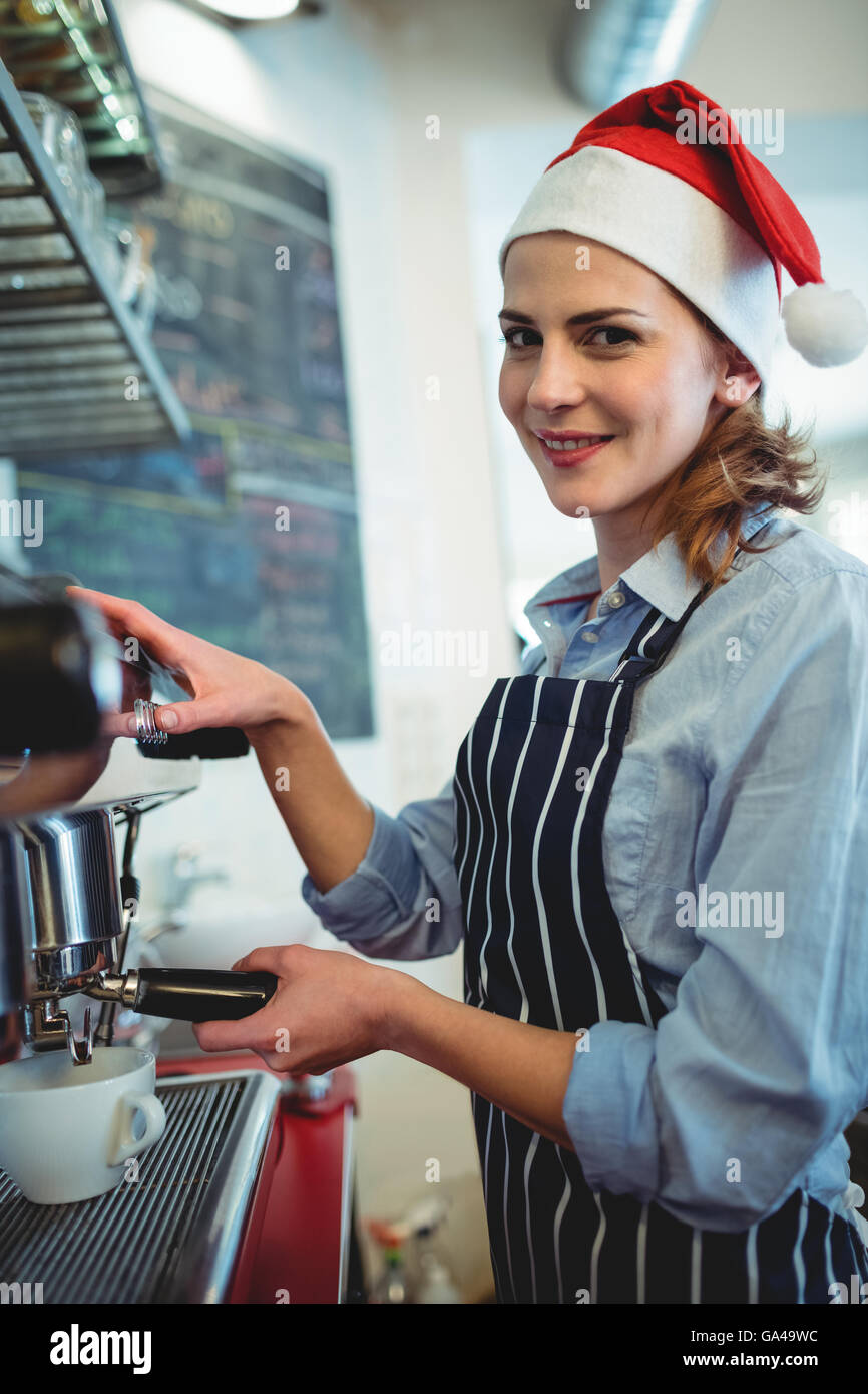 Portrait of waitress using coffee maker at cafeteria during Christmas ...