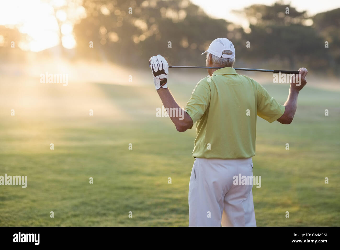 Rear view of mature golfer carrying golf club Stock Photo - Alamy