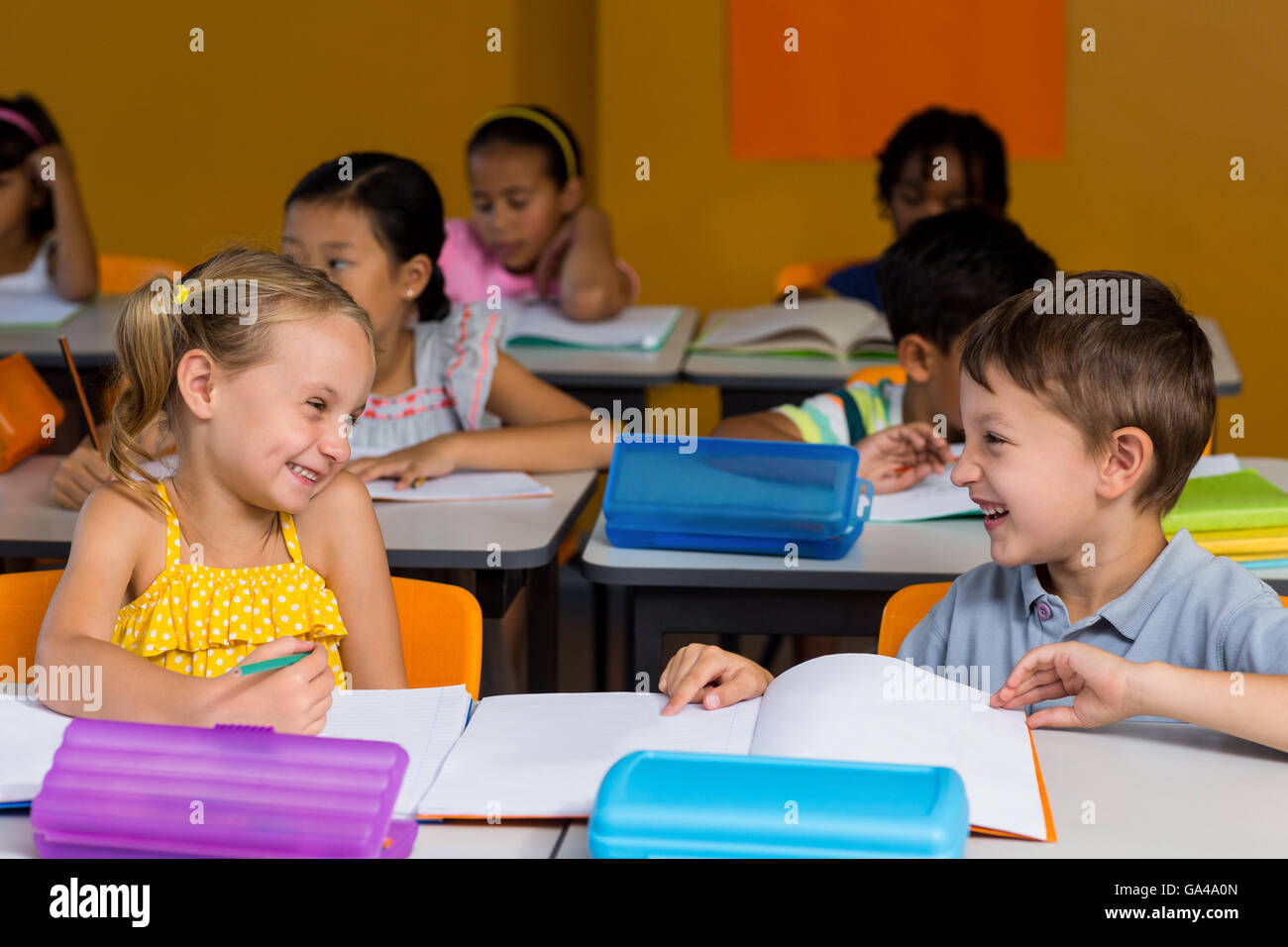 Classmates laughing in classroom Stock Photo - Alamy