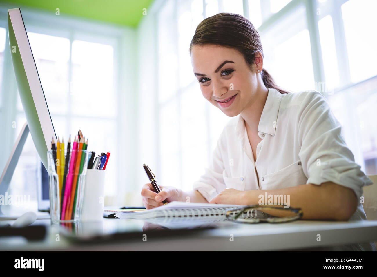 Smart graphic designer writing on document Stock Photo - Alamy