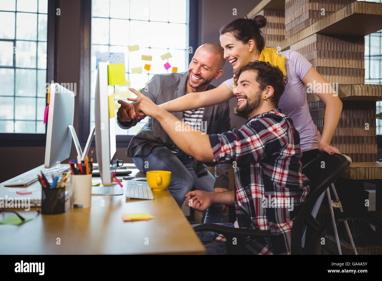 Cheerful business people pointing at computer Stock Photo - Alamy