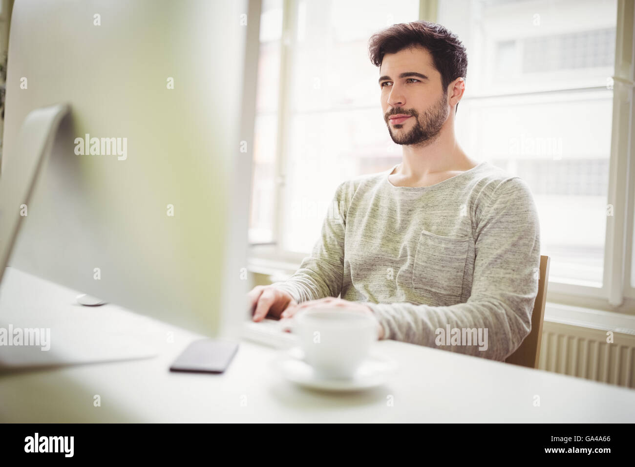 Confident businessman working on computer in office Stock Photo - Alamy