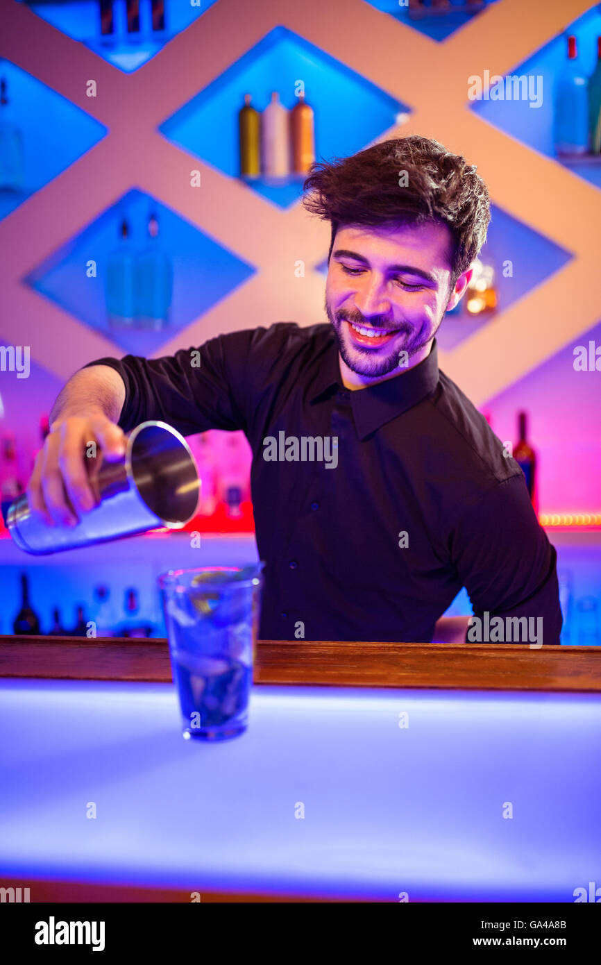 Bartender pouring cocktail in glass Stock Photo - Alamy