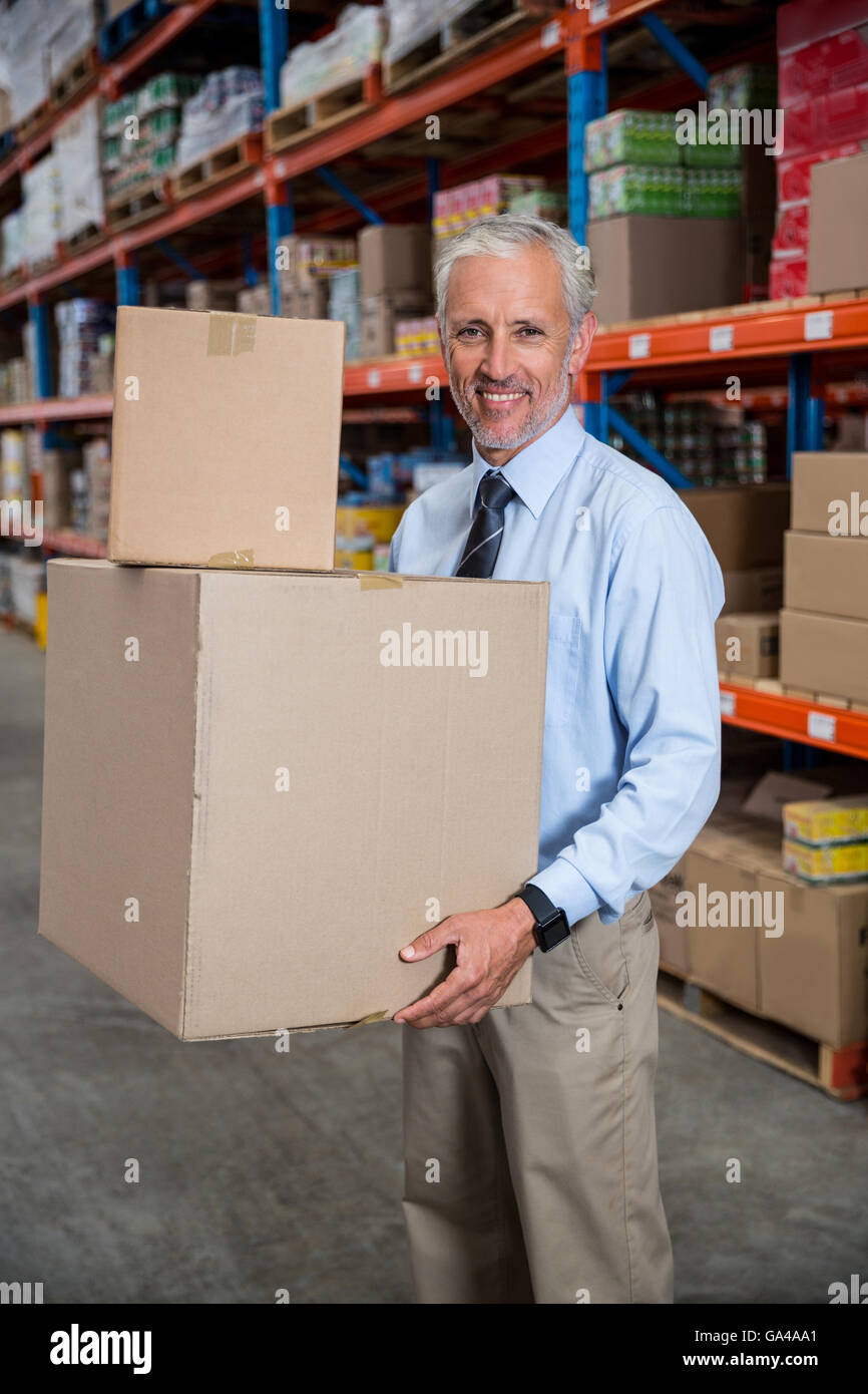 Smiling worker holding boxes Stock Photo - Alamy