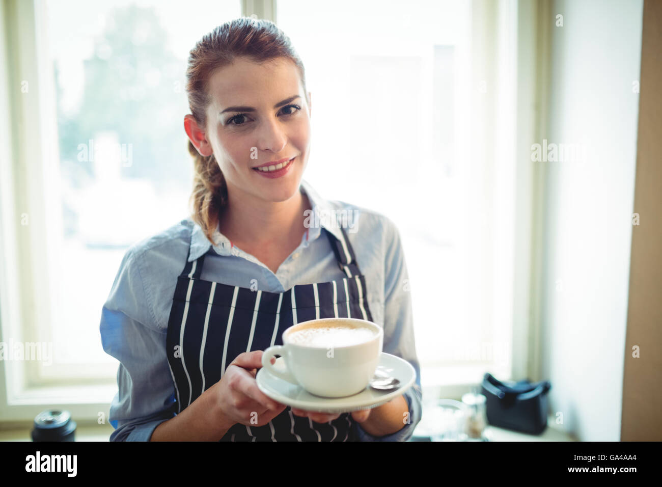 Portrait of happy waitress offering coffee at cafe Stock Photo - Alamy