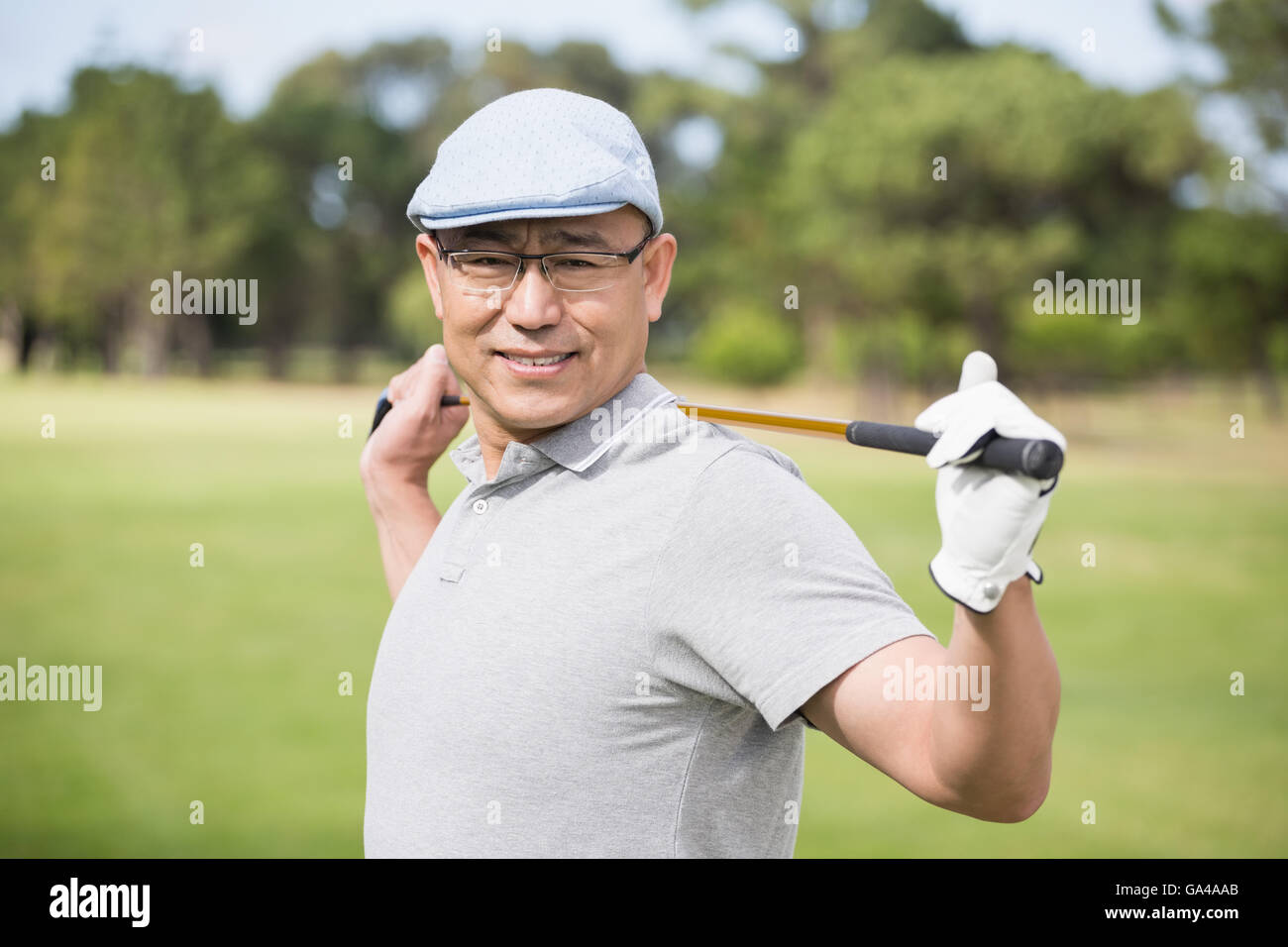 Side view of confident man holding golf club Stock Photo - Alamy