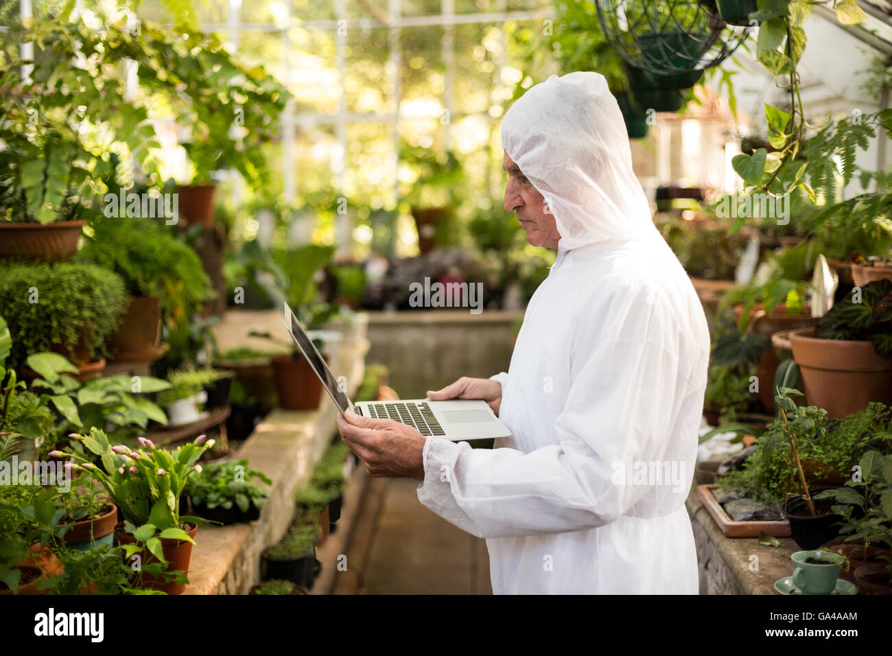 Male scientist in clean suit using laptop Stock Photo - Alamy