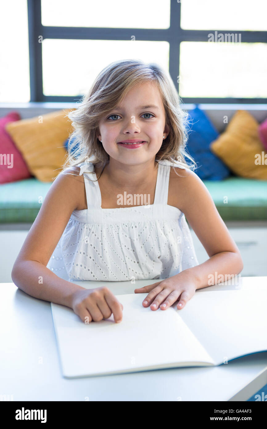 Smiling girl studying in school library Stock Photo - Alamy