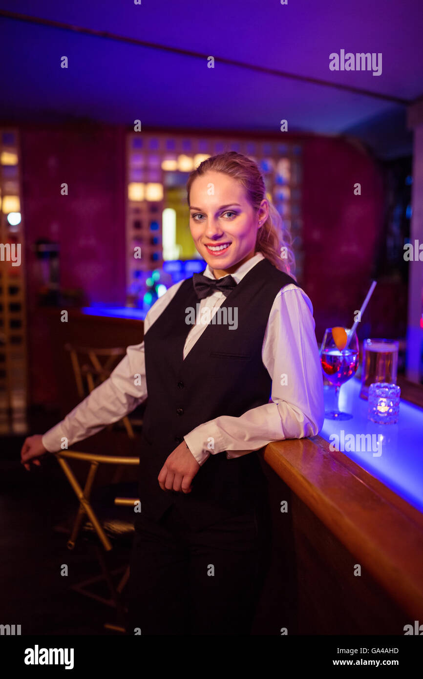 Beautiful bartender leaning at bar counter Stock Photo - Alamy